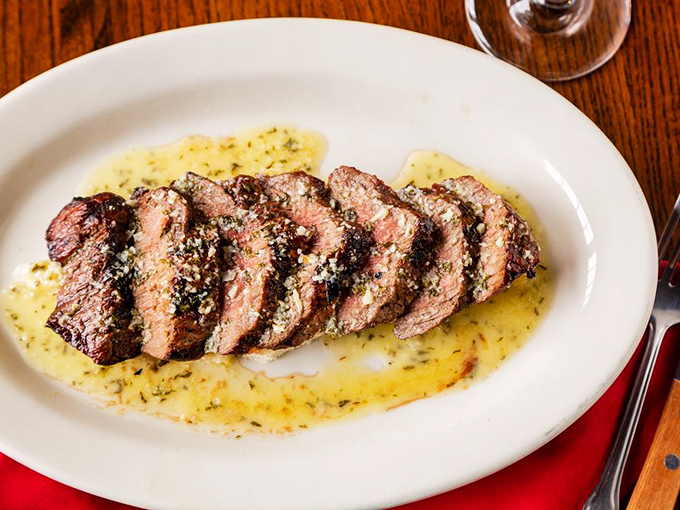 Sliced steak perfection! Each piece is a tender testament to the chef's skill, basking in a buttery sauce that'll make you want to lick the plate clean.