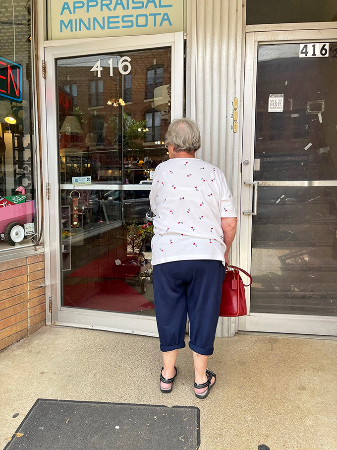 Window shopping or time traveling? This curious patron seems caught between eras, peering into a portal of Minnesota's past.