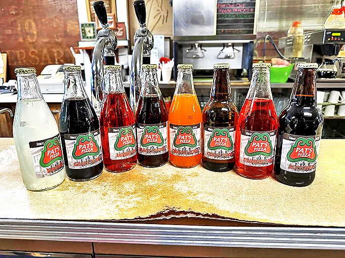 "Pat's own soda lineup: Bubbles of joy in every sip!" These colorful bottles are like a liquid rainbow, ready to complement your pizza adventure.