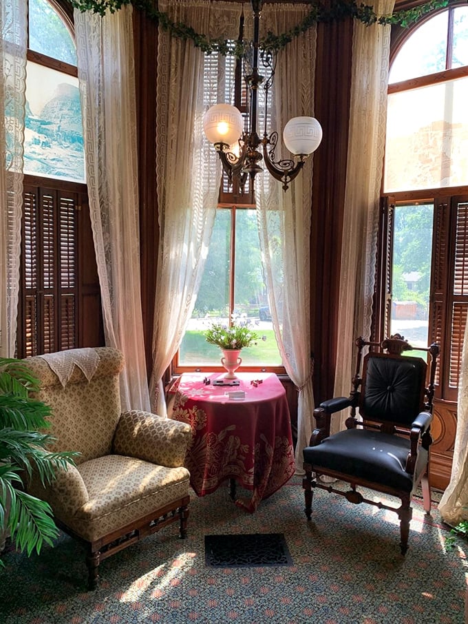 A room with a view... and enough drapery to outfit a small army of curtain-wearing ghosts. Victorian chic meets cozy nook perfection.