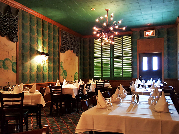 Green with envy! This emerald dining room, with its retro light fixtures and cozy booths, sets the stage for a night of culinary indulgence.