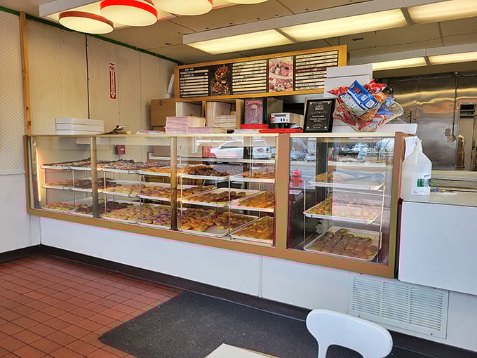 Welcome to donut paradise! This display case is like a museum of circular art, each piece more tempting than the last.