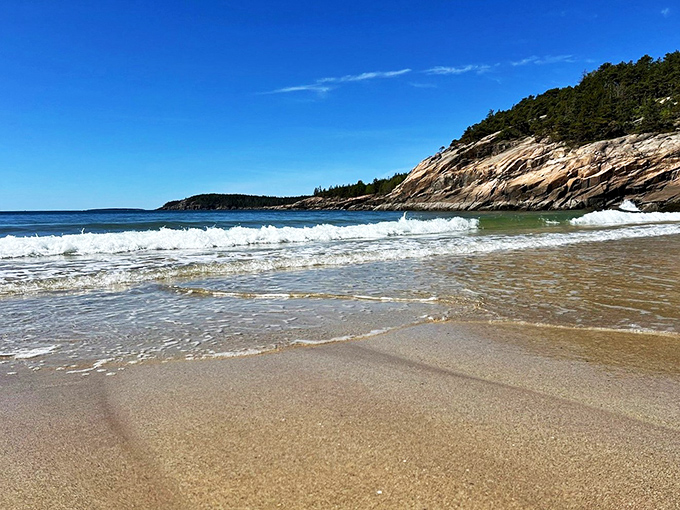 Sandy oasis nestled between granite giants. It's the beach equivalent of finding a curly fry in your regular fries - unexpected and delightful!