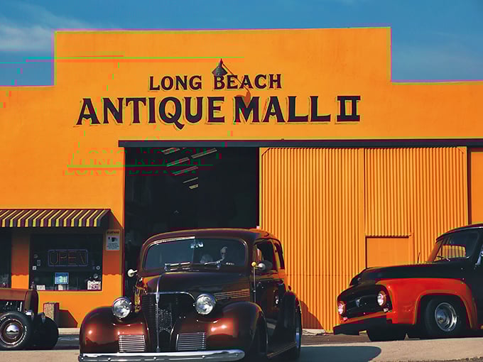 Welcome to the time machine! This vibrant orange facade houses more memories than your grandma's attic, with classic cars that'll make any gearhead swoon.