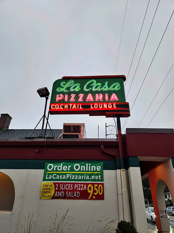 Neon dreams come true! La Casa Pizzaria's sign beckons like a lighthouse for the pizza-starved, promising a safe harbor of cheesy delights.