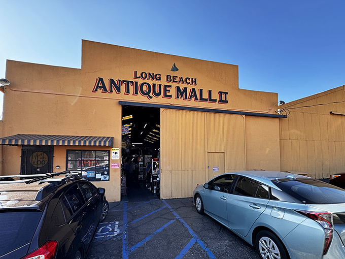 Welcome to the time machine! This vibrant orange facade houses more memories than your grandma's attic, with classic cars that'll make any gearhead swoon.