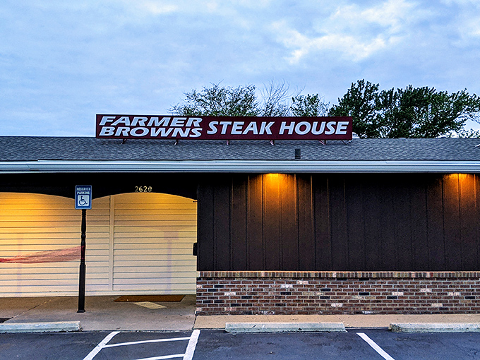 The unassuming exterior of Farmer Brown's Steak House stands like a beacon at dusk, promising carnivorous delights within its humble walls.