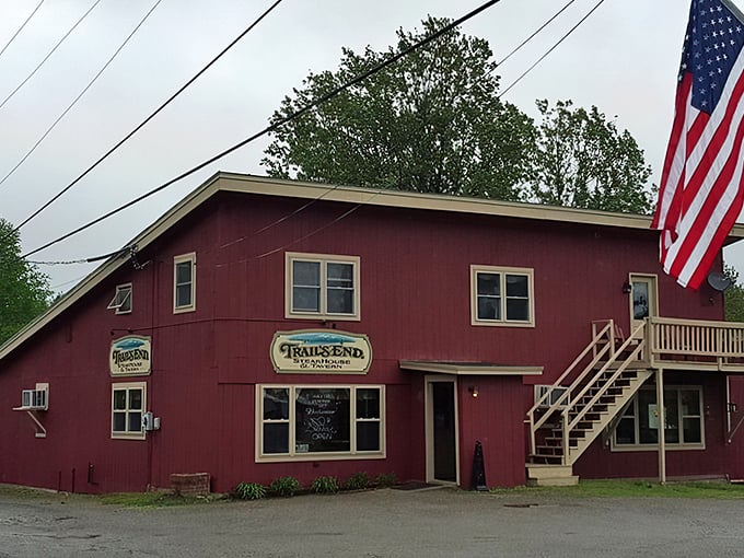 A red beacon of culinary delight! Trail's End Steakhouse stands proud, its rustic charm beckoning hungry travelers like a meaty lighthouse in the Maine wilderness.