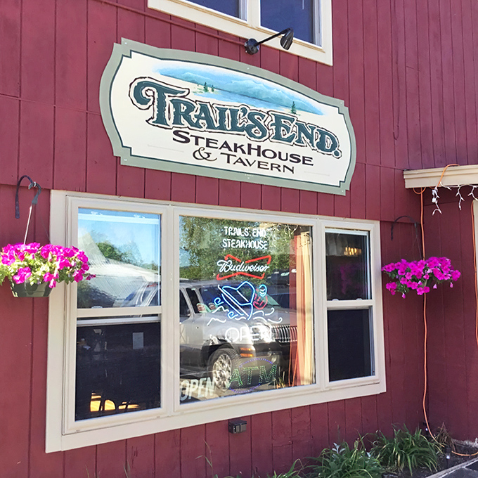 A red beacon of culinary delight! Trail's End Steakhouse stands proud, its rustic charm beckoning hungry travelers like a meaty lighthouse in the Maine wilderness.