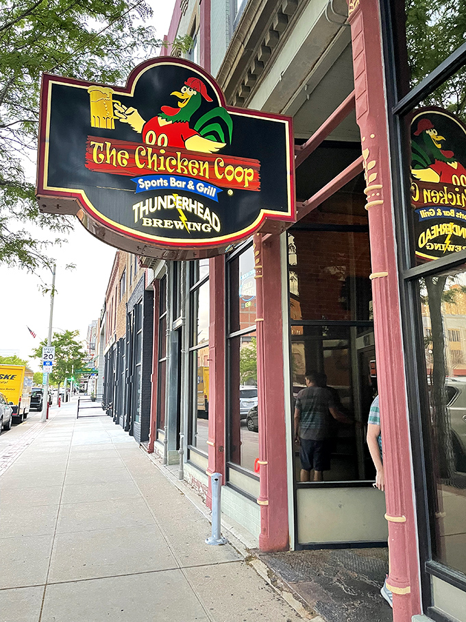 Welcome to flavor town! The Chicken Coop's sign promises a clucking good time with its cheeky rooster mascot and promise of sports, grub, and brews.
