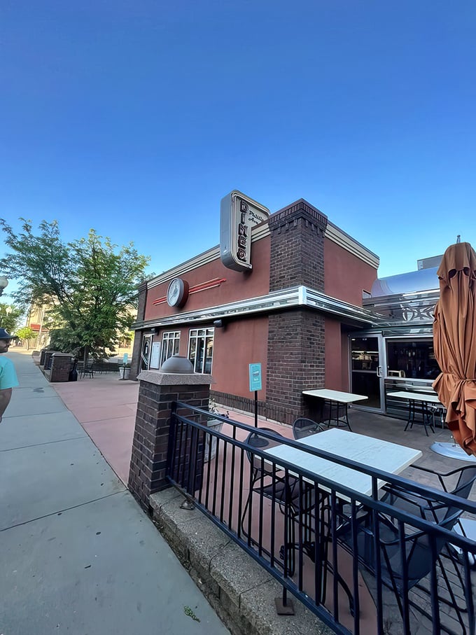 Step back in time! This salmon-pink facade isn't just a building, it's a portal to the golden age of chrome and vinyl.