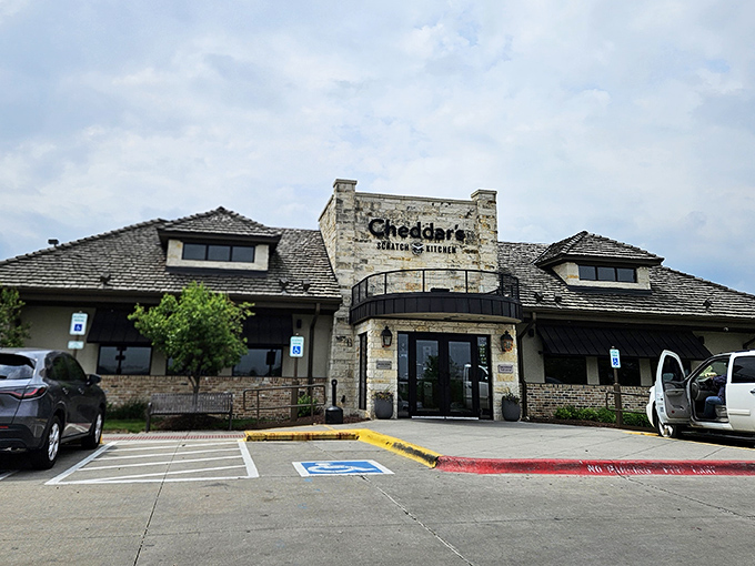 The stone facade of Cheddar's Scratch Kitchen stands like a comfort food castle, promising homestyle delights within its welcoming walls.