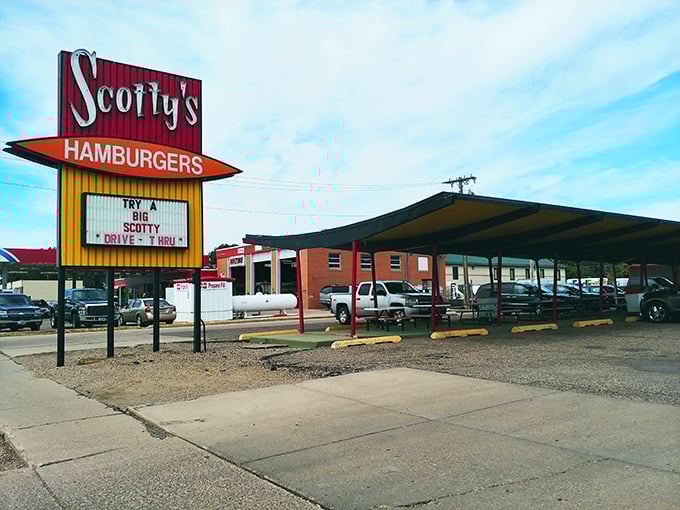 Welcome to burger paradise! Scotty's iconic sign beckons like a neon-lit promise of deliciousness, with a drive-thru that's been serving up happiness since 1964.