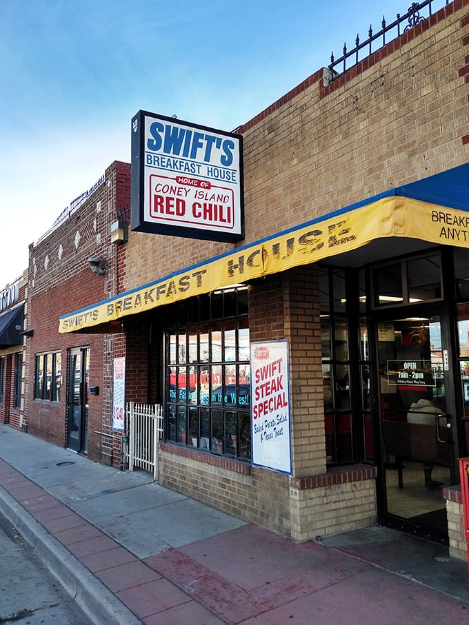Welcome to flavor town! Swift's Breakfast House stands proud, its yellow awning a beacon of hope for hungry souls seeking breakfast bliss in Denver.