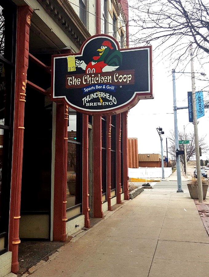 Welcome to flavor town! The Chicken Coop's sign promises a clucking good time with its cheeky rooster mascot and promise of sports, grub, and brews.