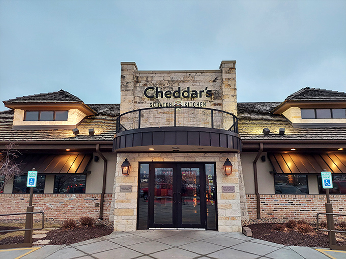 The stone facade of Cheddar's Scratch Kitchen stands like a comfort food castle, promising homestyle delights within its welcoming walls.