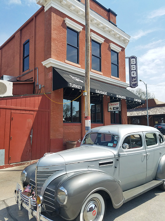 The historic brick building housing Boyd & Charlie's stands like a time capsule of Americana, complete with vintage car and promises of smoky delights within.
