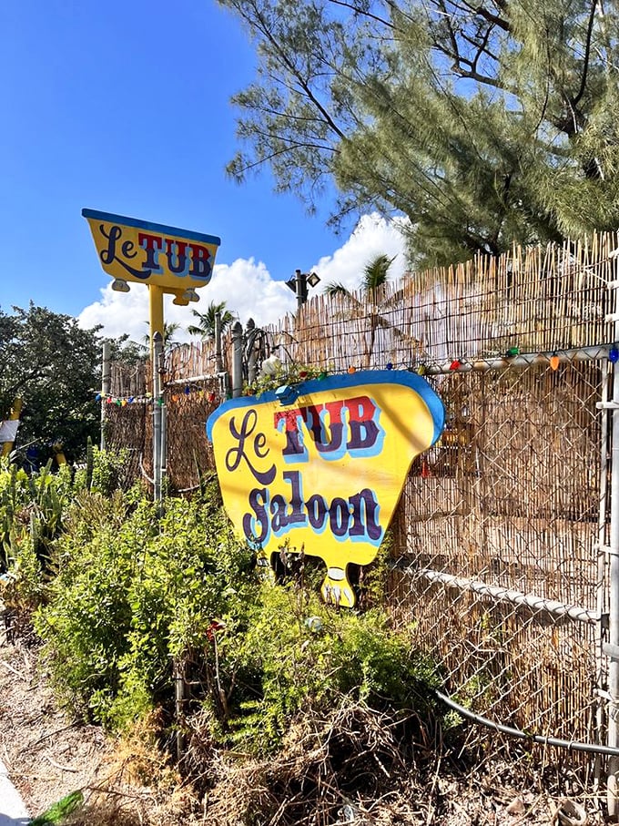 Welcome to Le Tub, where palm trees sway and burgers reign supreme. This quirky entrance is your portal to a world of culinary delights and coastal charm.