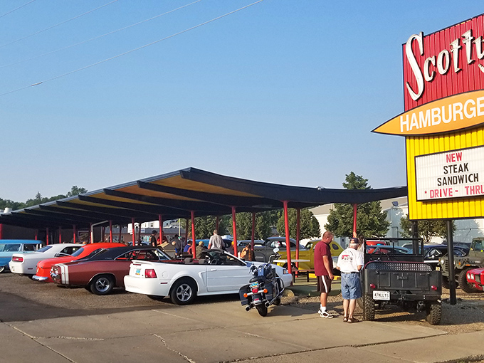 Welcome to burger paradise! Scotty's iconic sign beckons like a neon-lit promise of deliciousness, with a drive-thru that's been serving up happiness since 1964.