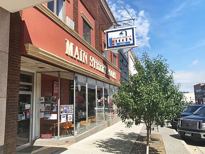 Step into a literary wonderland! Main Street Books beckons with its charming red brick facade and blossoming trees, promising adventures between the pages.
