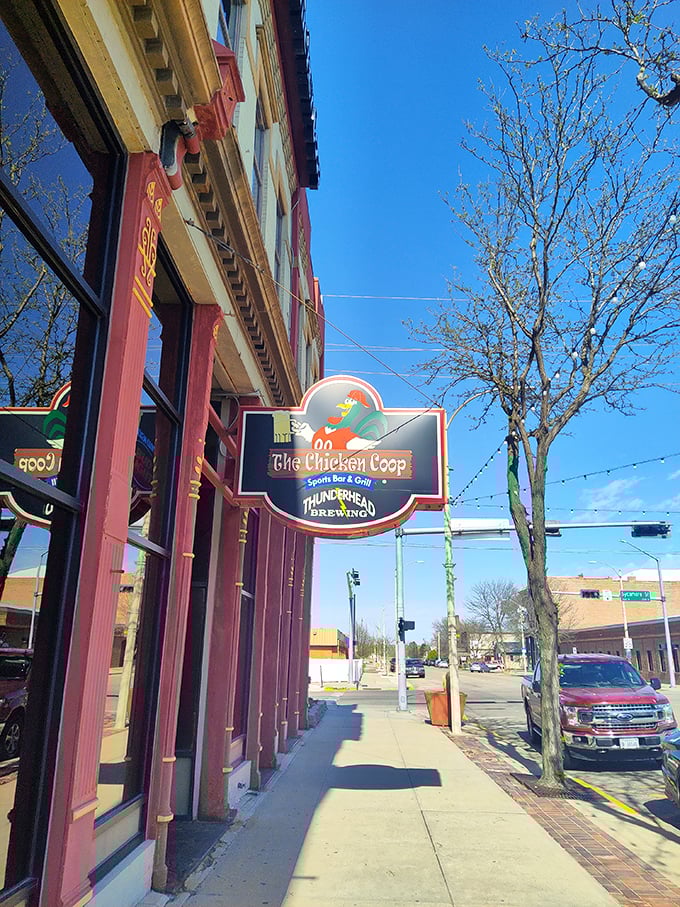 Welcome to flavor town! The Chicken Coop's sign promises a clucking good time with its cheeky rooster mascot and promise of sports, grub, and brews.