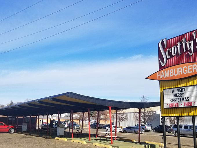 Welcome to burger paradise! Scotty's iconic sign beckons like a neon-lit promise of deliciousness, with a drive-thru that's been serving up happiness since 1964.