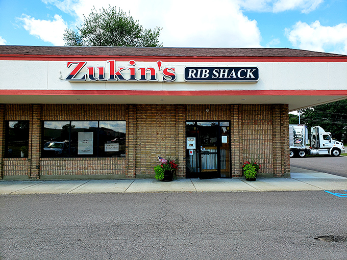 Welcome to BBQ paradise! Zukin's Rib Shack stands proud, its red and white sign a beacon of hope for hungry souls seeking smoky salvation.