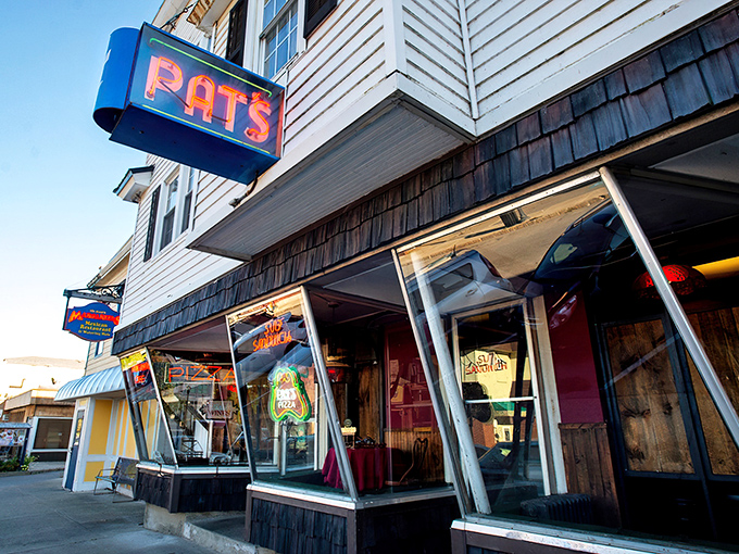 Welcome to pizza paradise! Pat's neon sign beckons like a lighthouse, guiding hungry souls to a haven of cheesy delights.
