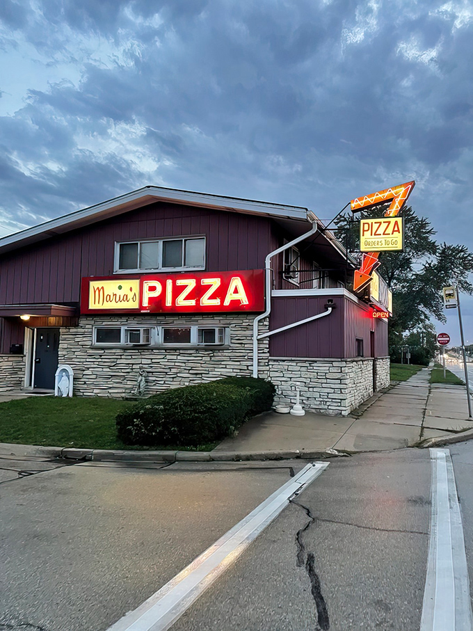 A beacon of cheesy delight! Maria's Pizza stands proud, its neon sign a siren call to hungry souls seeking comfort in carbs and melted goodness.
