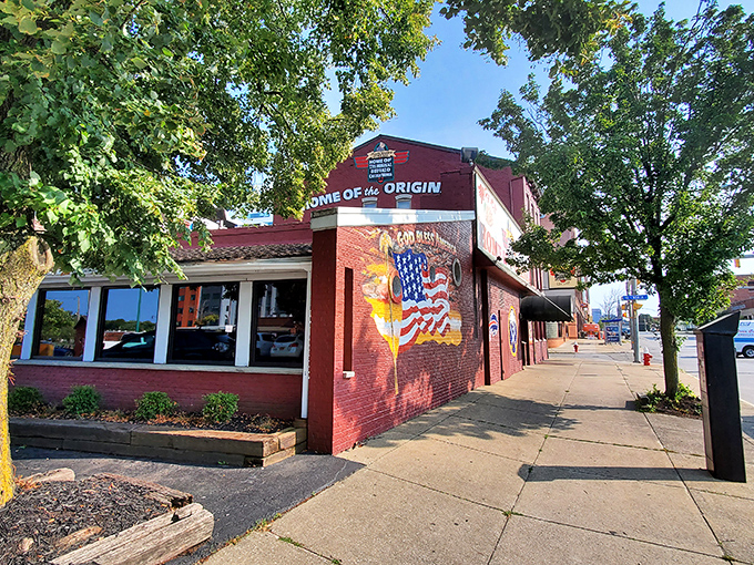 The unassuming red brick exterior of Anchor Bar proudly declares itself "Home of the Origin" &ndash; where culinary history was made one fateful night in 1964.