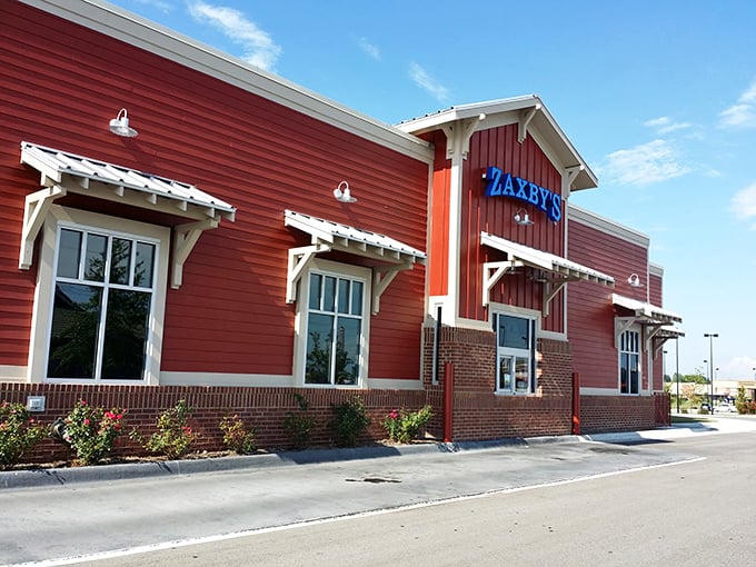 Welcome to flavor town! Zaxby's bold blue sign beckons like a neon lighthouse, guiding hungry souls to a chicken paradise.