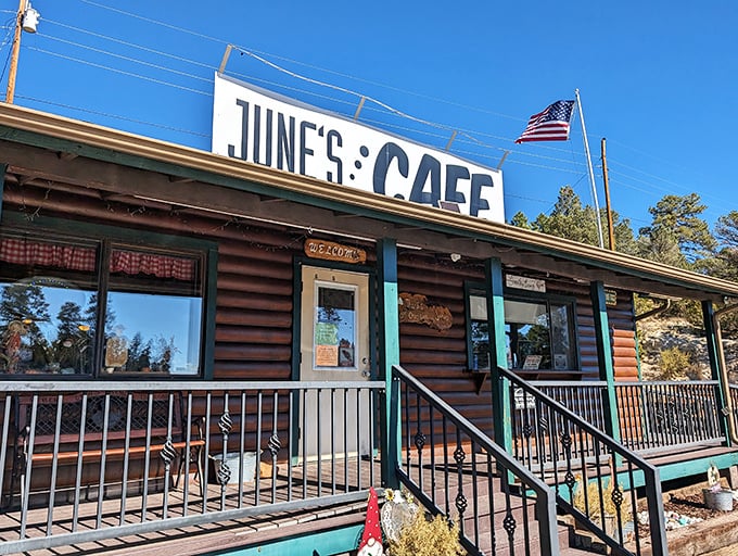 The log cabin charm of June's Cafe stands proudly against Arizona's blue sky, complete with American flag &ndash; a beacon of breakfast hope for hungry travelers.