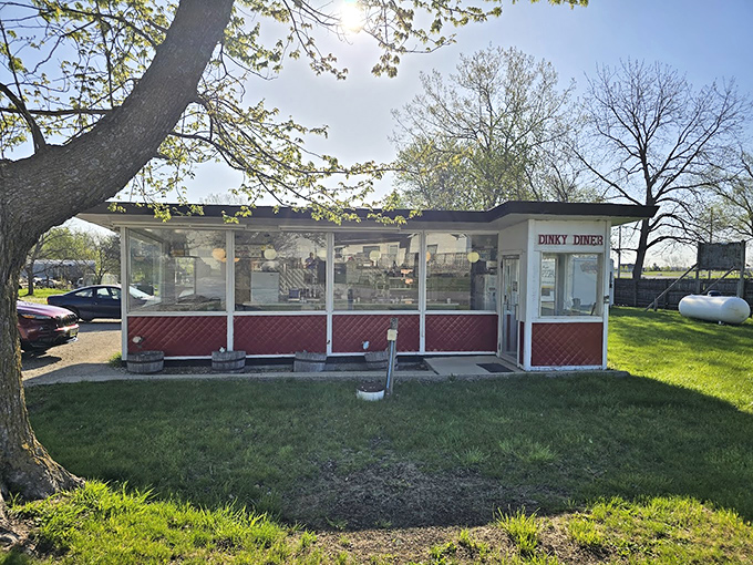 A slice of Americana, served with a side of nostalgia! This little red-and-white diner looks like it jumped straight out of a Norman Rockwell painting.
