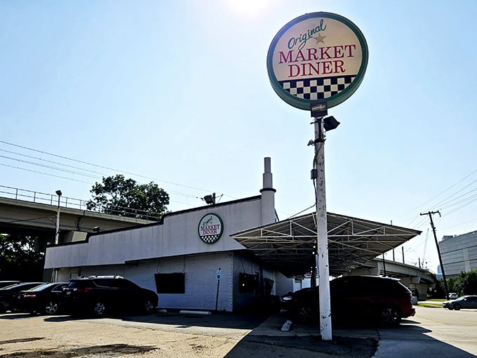 The iconic circular sign of Original Market Diner stands tall against the Dallas sky, a beacon for breakfast enthusiasts since the 1950s.