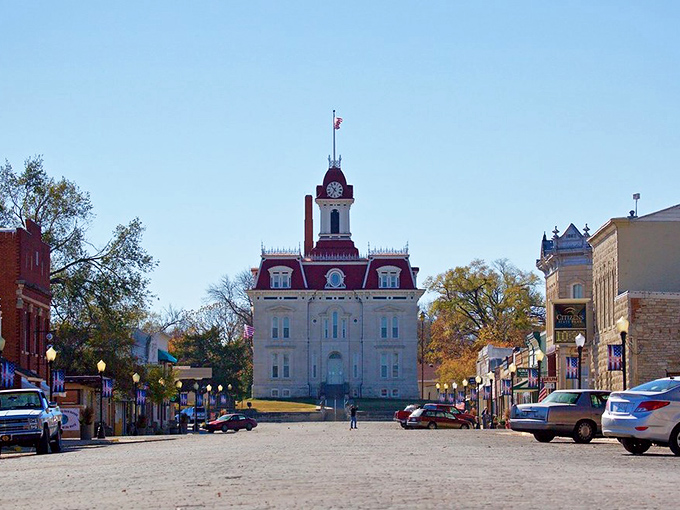 The Chase County Courthouse stands like a Victorian sentinel at the end of Broadway Street, its red mansard roof and limestone walls creating an unforgettable silhouette against the Kansas sky.
