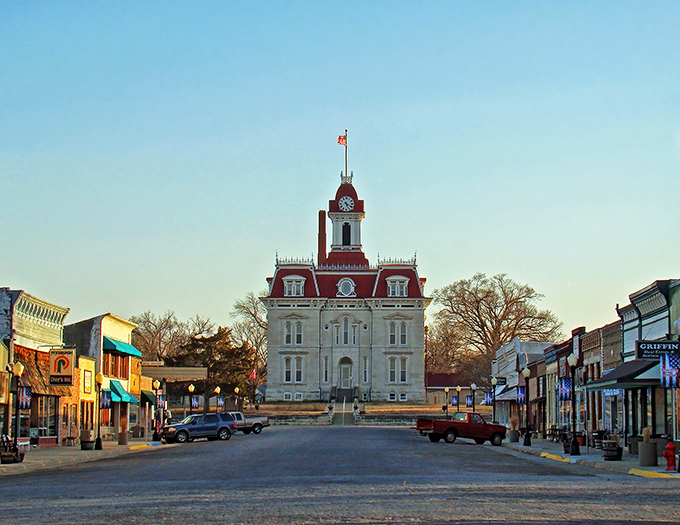 The Chase County Courthouse stands like a Victorian sentinel at the end of Broadway Street, its red mansard roof and limestone walls creating an unforgettable silhouette against the Kansas sky.