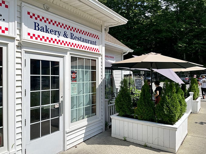 A slice of Americana awaits! This charming exterior, with its red-checkered trim and inviting patio, promises comfort food that'll warm your soul.