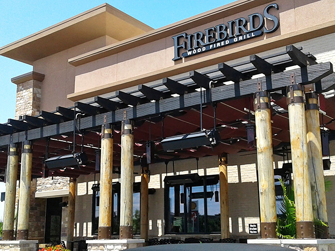 Welcome to Firebirds, where rustic charm meets culinary flair! This exterior promises a feast for the senses, with those rugged wooden pillars practically begging you to come inside.