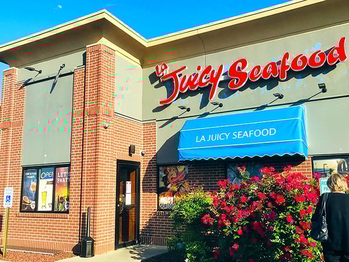 Welcome to seafood paradise! La Juicy Seafood's exterior promises a feast for the senses, with its cheerful blue awnings and grinning crab mascot.