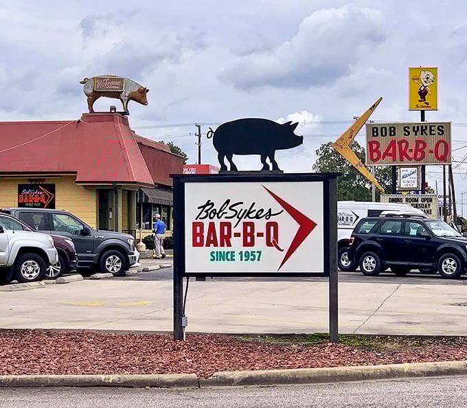 Welcome to BBQ paradise! Bob Sykes' iconic sign beckons like a smoky siren, promising meaty delights that'll make your taste buds do a happy dance.