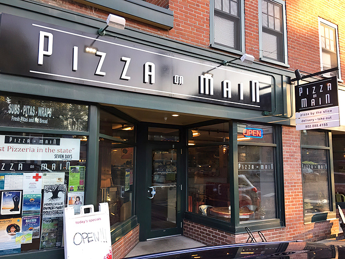 A slice of small-town charm! Pizza on Main's brick facade and colorful chairs invite you to savor a taste of Vermont hospitality.