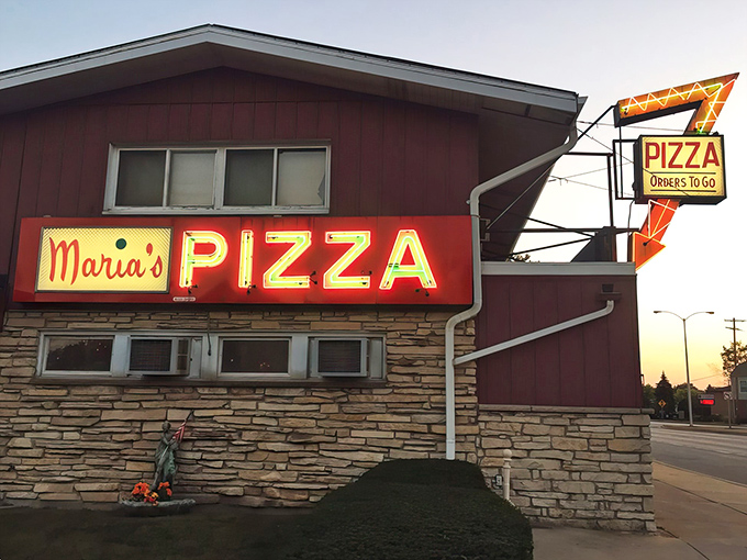A beacon of cheesy delight! Maria's Pizza stands proud, its neon sign a siren call to hungry souls seeking comfort in carbs and melted goodness.