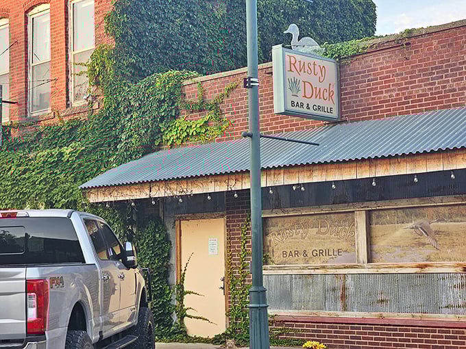 Welcome to the Rusty Duck, where the sign may be weathered, but the steaks are always fresh! This unassuming exterior hides a carnivore's paradise within.