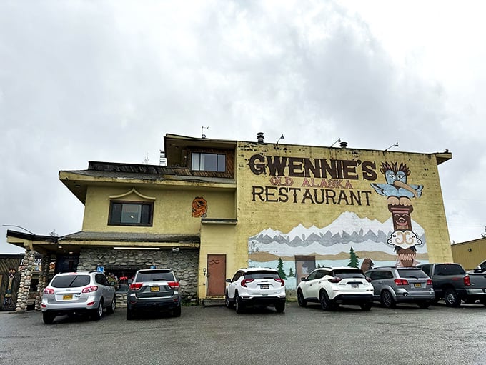 The pale yellow exterior of Gwennie's stands like a cheerful sentinel against Alaska's often-gray skies, complete with iconic totem pole mural.
