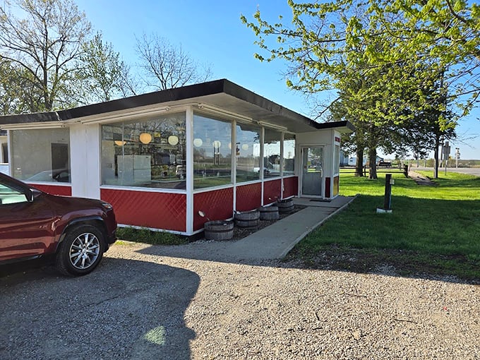 A slice of Americana, served with a side of nostalgia! This little red-and-white diner looks like it jumped straight out of a Norman Rockwell painting.