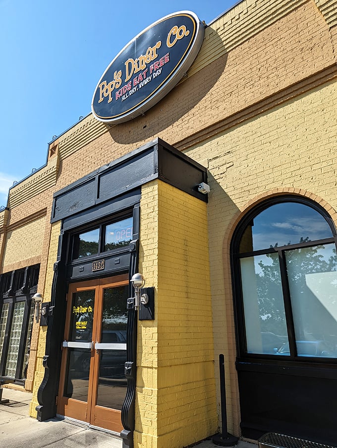The sunshine-yellow exterior of Pop's Diner Co. stands out like a beacon for breakfast lovers, promising comfort food salvation with its cheerful "Kids Eat Free" sign.