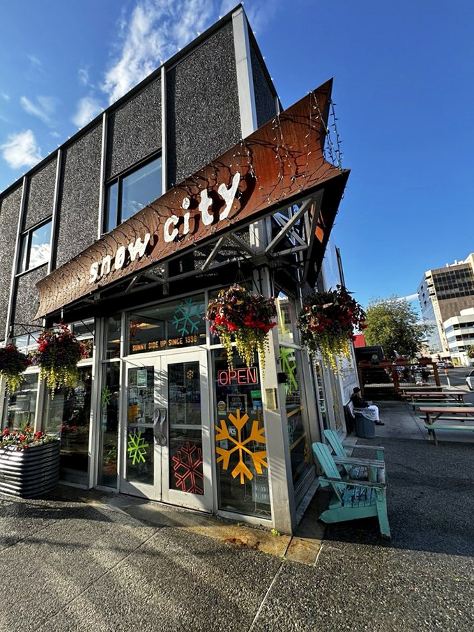 Welcome to Snow City Cafe, where the exterior is as inviting as a warm hug on a frosty Alaskan morning. Colorful flowers defy the chill, promising a cozy retreat inside.