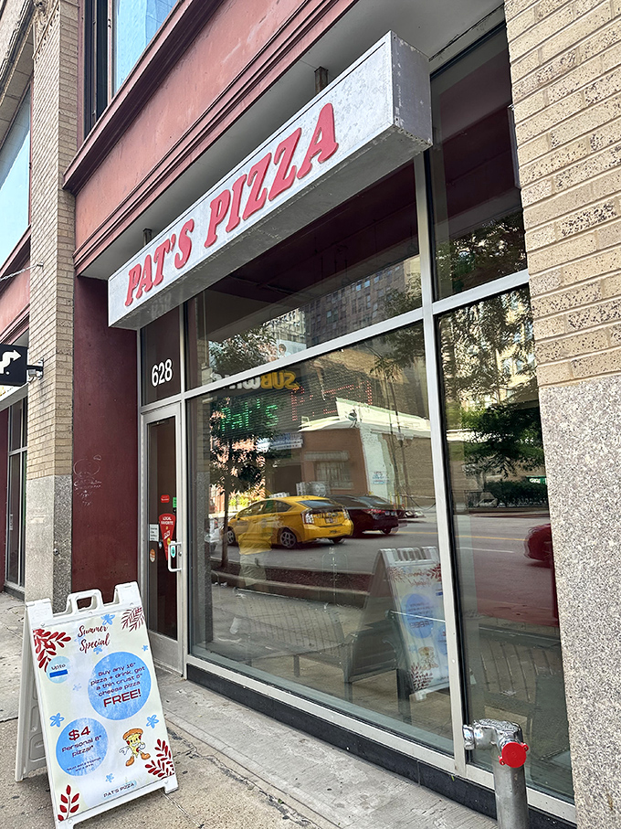 A slice of Americana! Pat's Pizza's unassuming storefront beckons with the promise of cheesy delights and a summer special that'll make your wallet as happy as your taste buds.