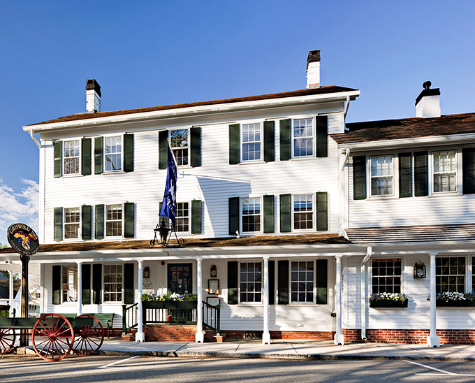 A slice of Americana served with a side of maritime charm. The Griswold Inn's white clapboard exterior whispers tales of centuries past, while the American flag proudly waves hello. 