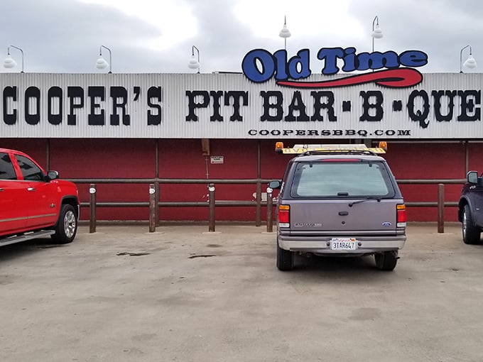Welcome to meat paradise! Cooper's Old Time Pit Bar-B-Que stands proud, its red-trimmed exterior promising smoky delights that'll make your taste buds do a happy dance.